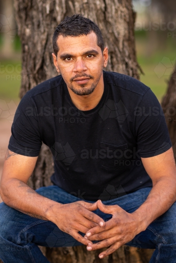 Image of man in jeans and tee looking intently into camera - Austockphoto