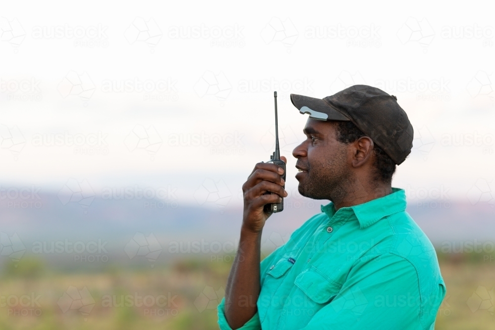 Image of Man in the outback taking on two-way-radio - Austockphoto