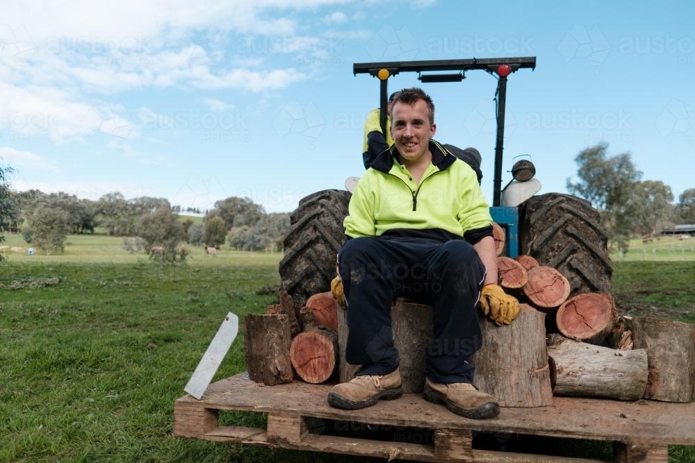 Image of Man on the Back of a Tractor - Austockphoto