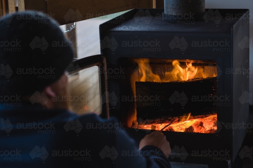 Image of Man poking fireplace - Austockphoto