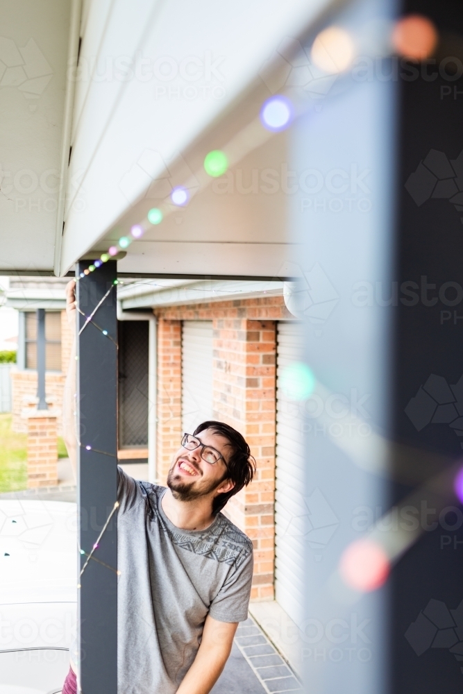 Image of Man putting up smart led Christmas lights on front of home ...
