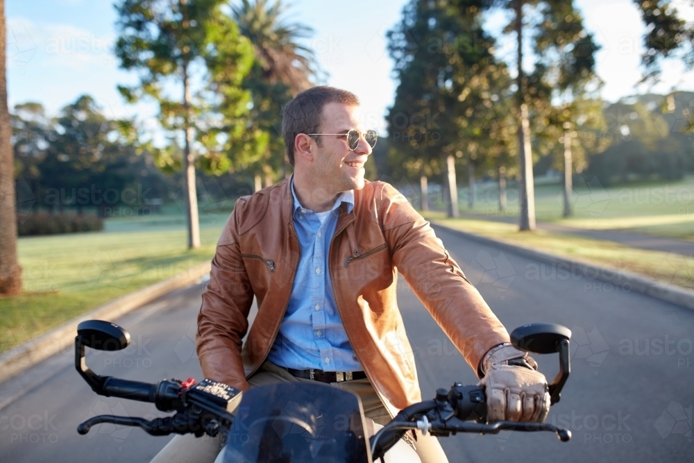Image of Man riding motorbike on road at parklands - Austockphoto
