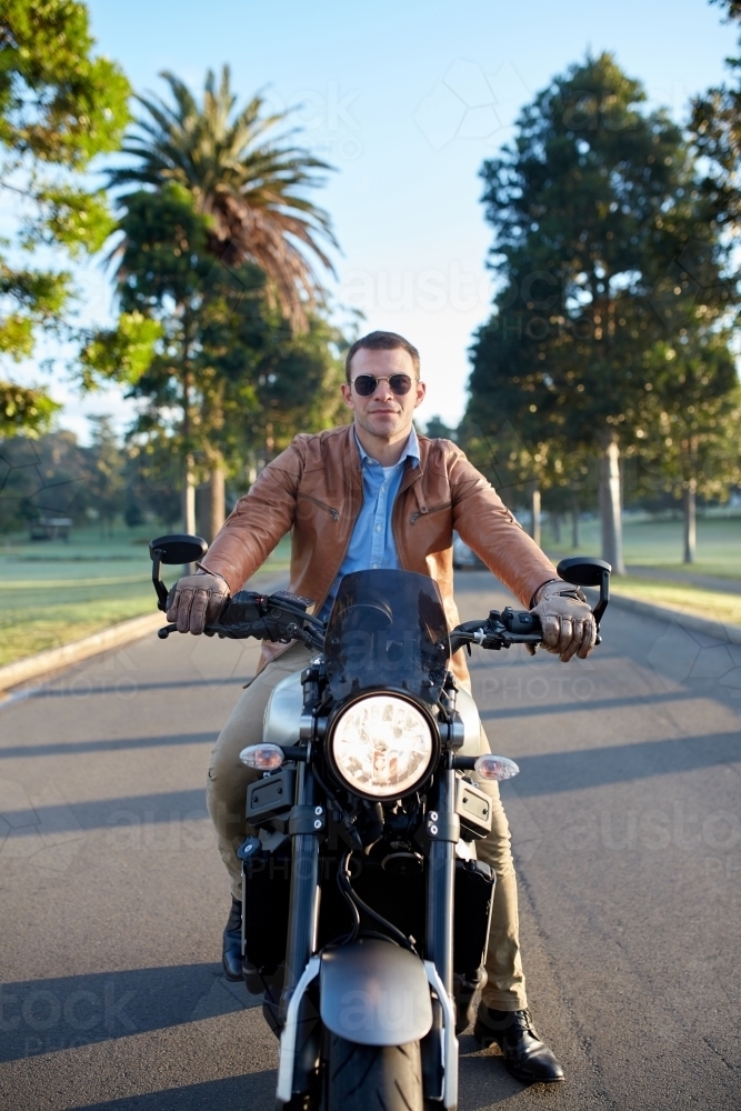 Image of Man riding motorbike on road at parklands - Austockphoto