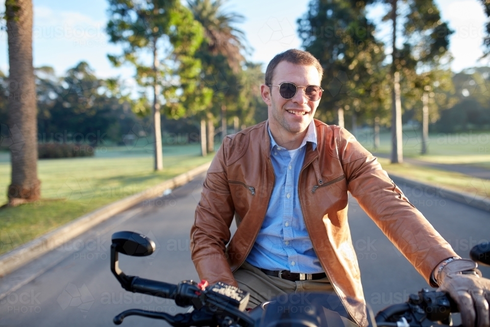 Image of Man riding motorbike on road at parklands - Austockphoto