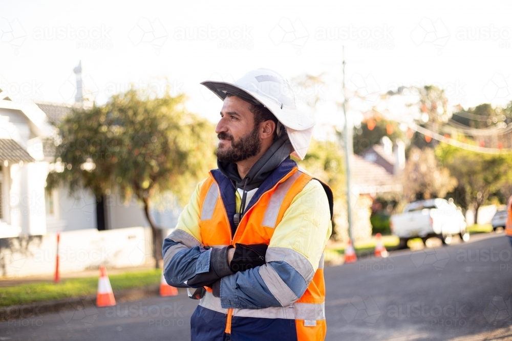 Image of Man road worker with beard wearing white hat looking away ...