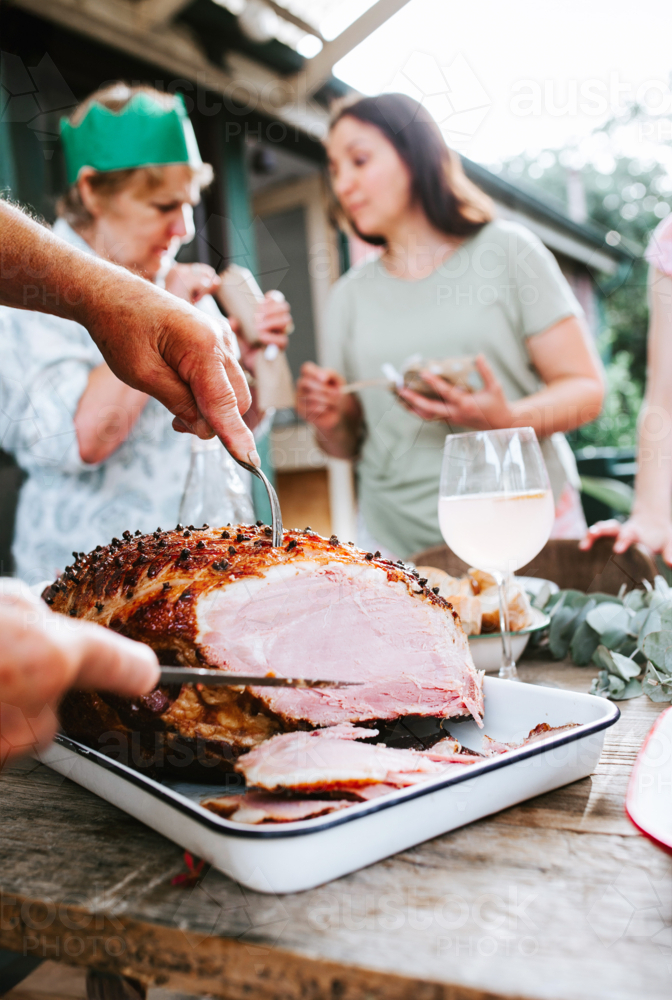 Image of Man's hand cutting thin slices of roasted ham. - Austockphoto