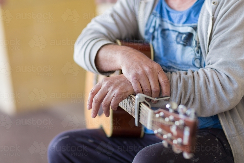 Image of Man's hands holding guitar - Austockphoto