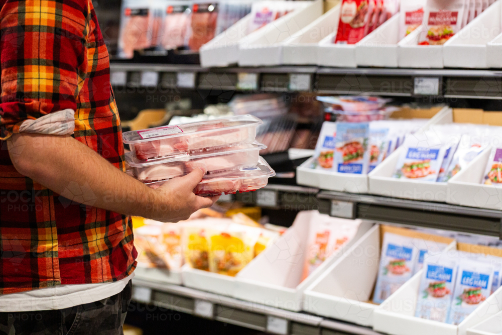 Image of man selecting meat at grocery store for that weeks dinner ...