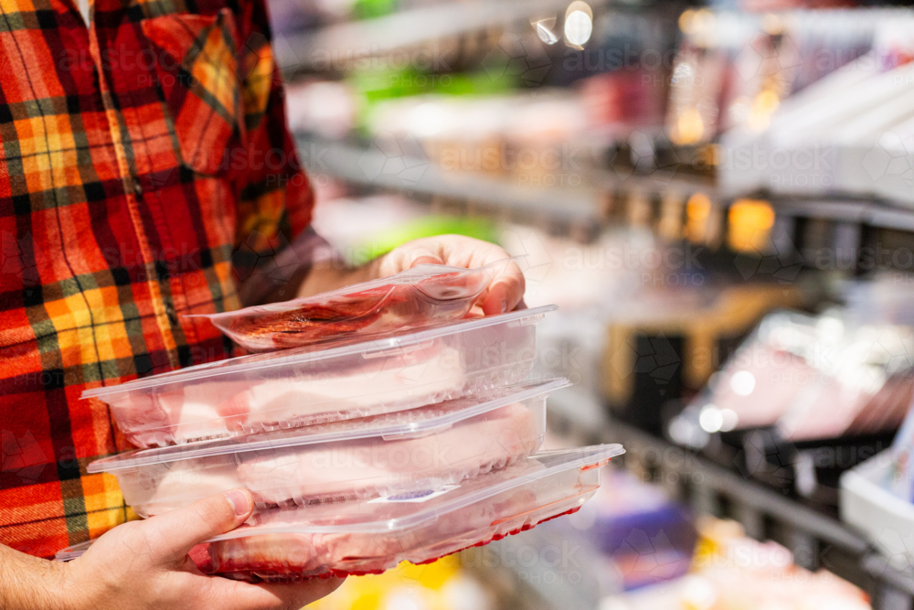 Image of man selecting meat at grocery store for that weeks dinner ...