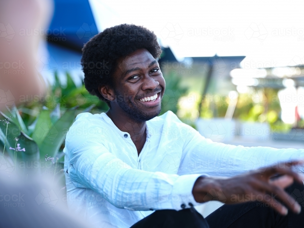 Image of Man smiling outside having a conversation - Austockphoto