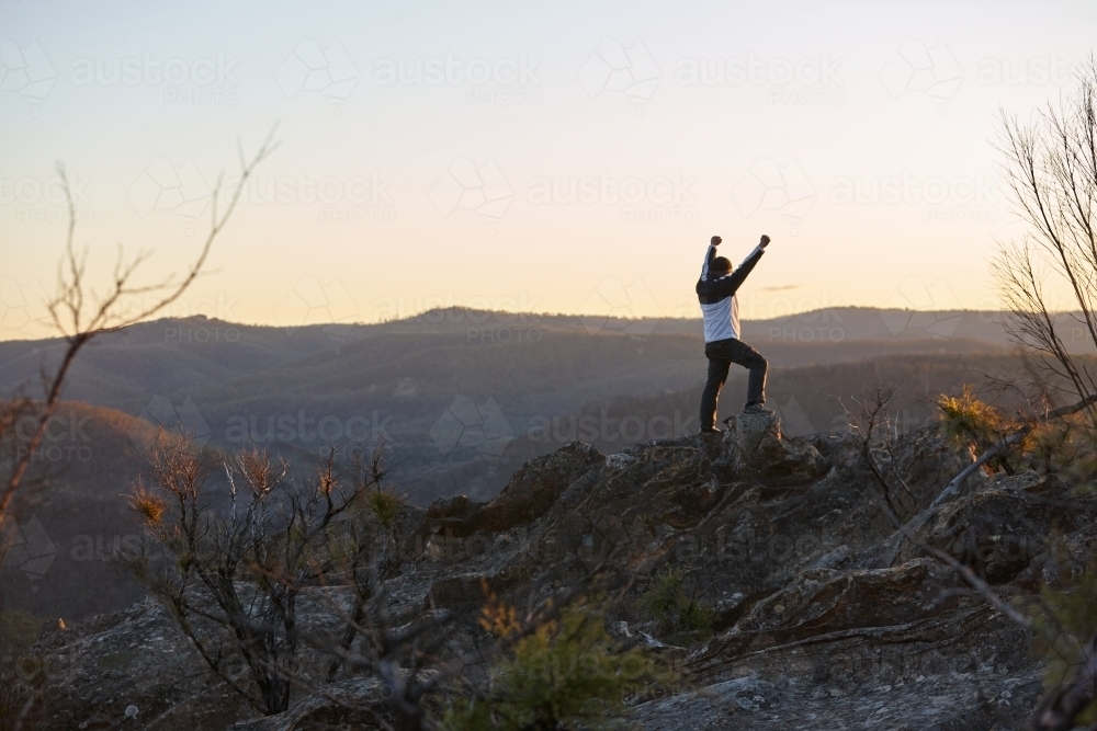 Image of Man standing looking out over mountains on sunset - Austockphoto