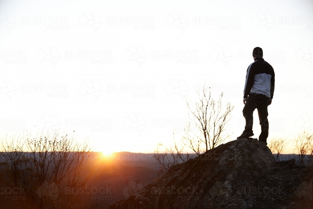 Image of Man standing looking out over mountains on sunset - Austockphoto