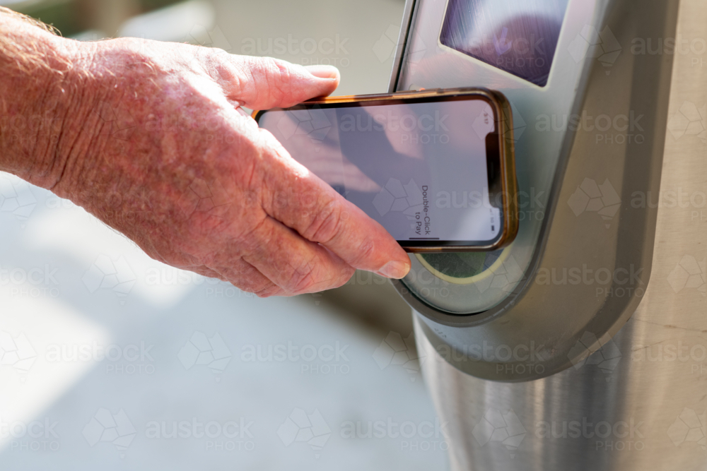 Image of man tapping on for public transport with his phone - Austockphoto