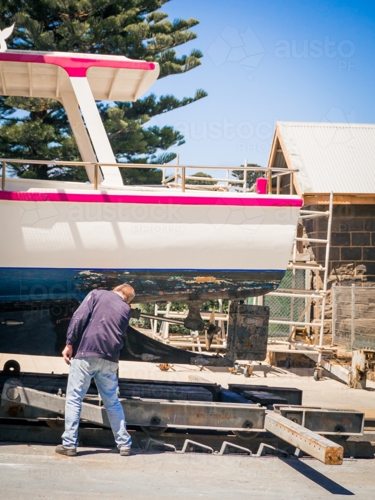 Image of Man working on a wooden boat - Austockphoto