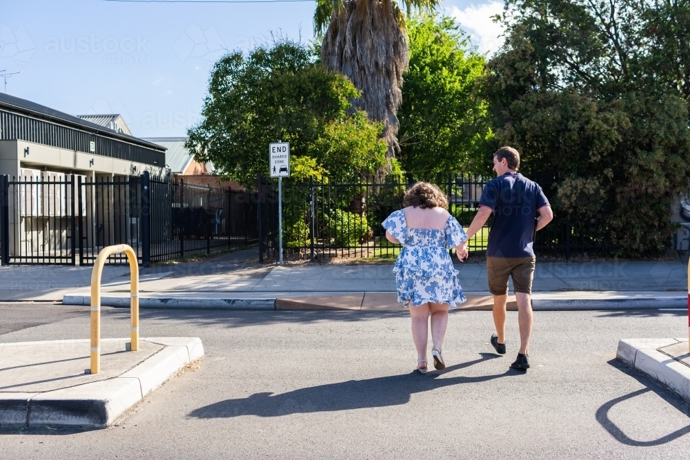 Image of man working with person with a disability helping her cross ...