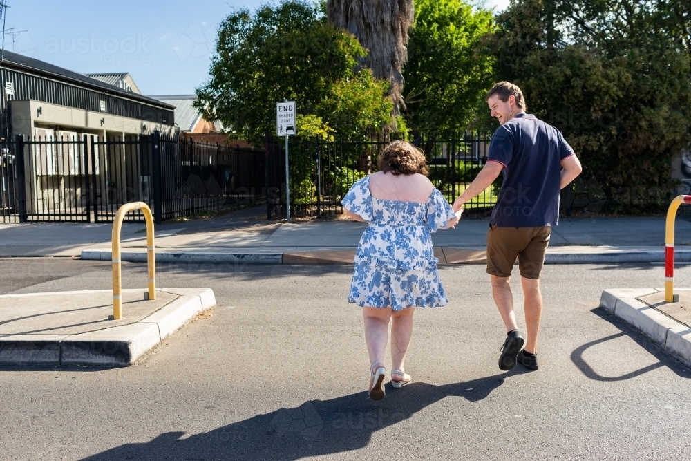 Image of man working with person with a disability helping her cross ...