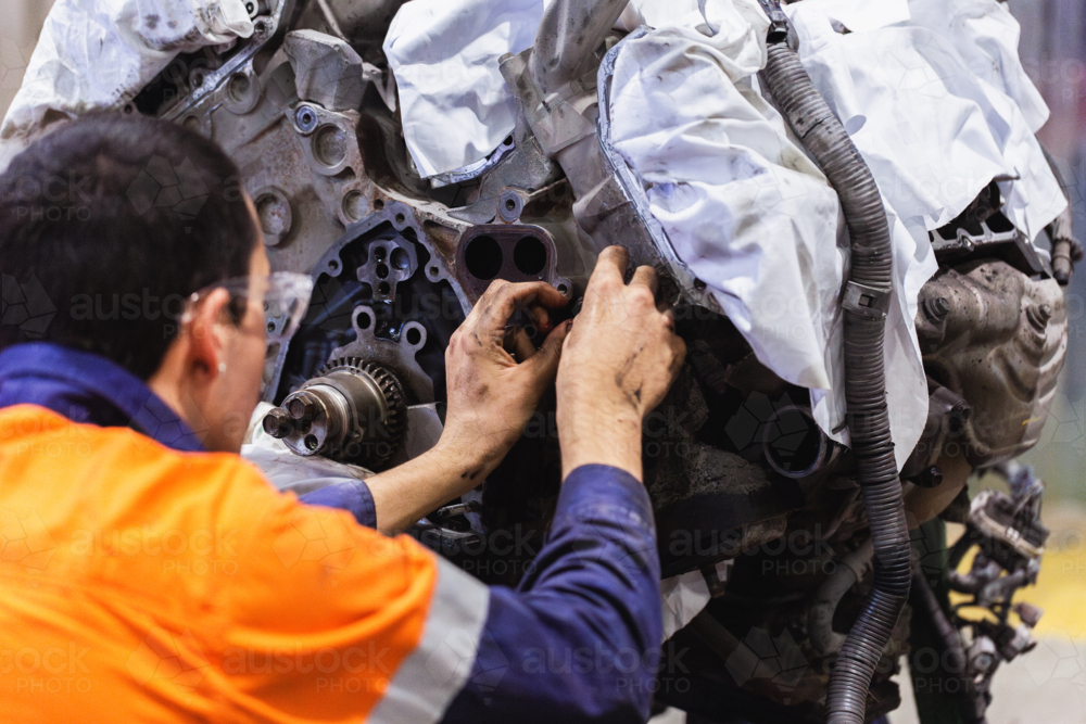Image of Mechanic in high vis clothing working on disassembled vehicle ...
