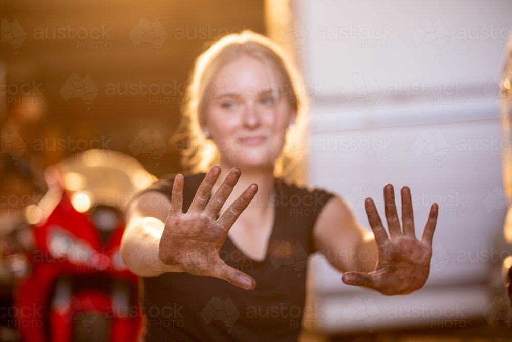 Image of Mechanic showing us her dirty greasy hands - Austockphoto