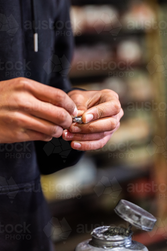 Image of Mechanics hands holding small mechanical part beside workbench ...