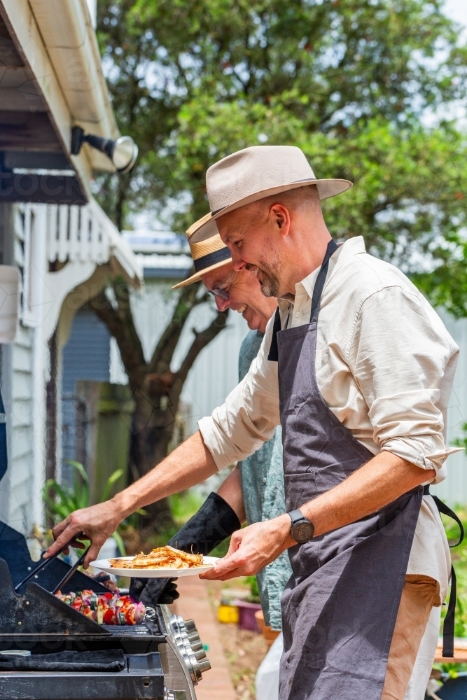 Image of men cooking lunch food on bbq in backyard of country home ...