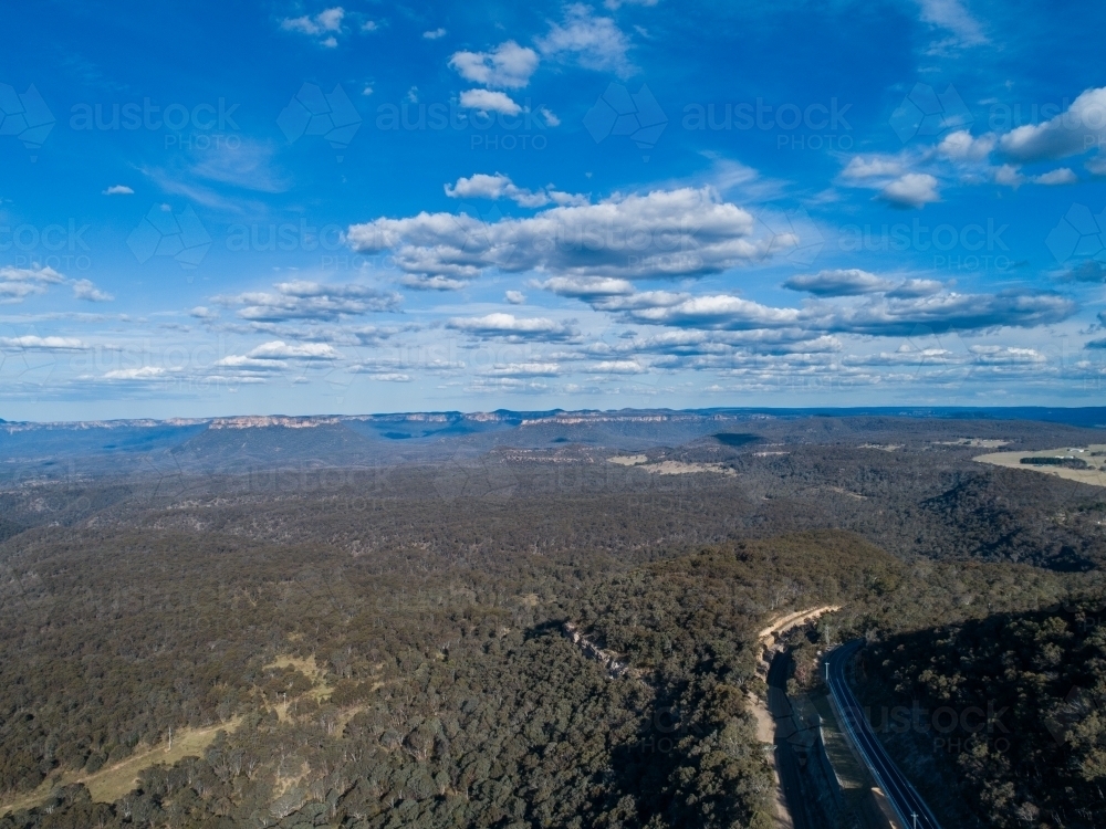 Image of Midday Australia with rolling hills covered in trees, cliffs ...