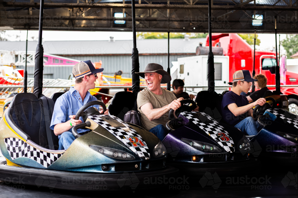 Image of Middle aged man riding on dodgem cars show ride at event with ...