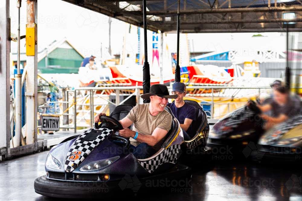 Image of Middle aged man riding on dodgem cars show ride at event with ...