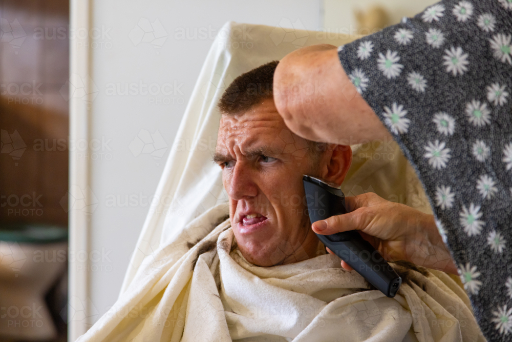 Image of Middle aged woman shaving beard of young man with disability ...
