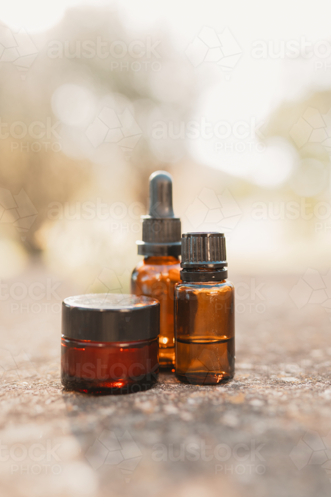 Image of Minimalist collection of amber essential oil bottles outdoors ...