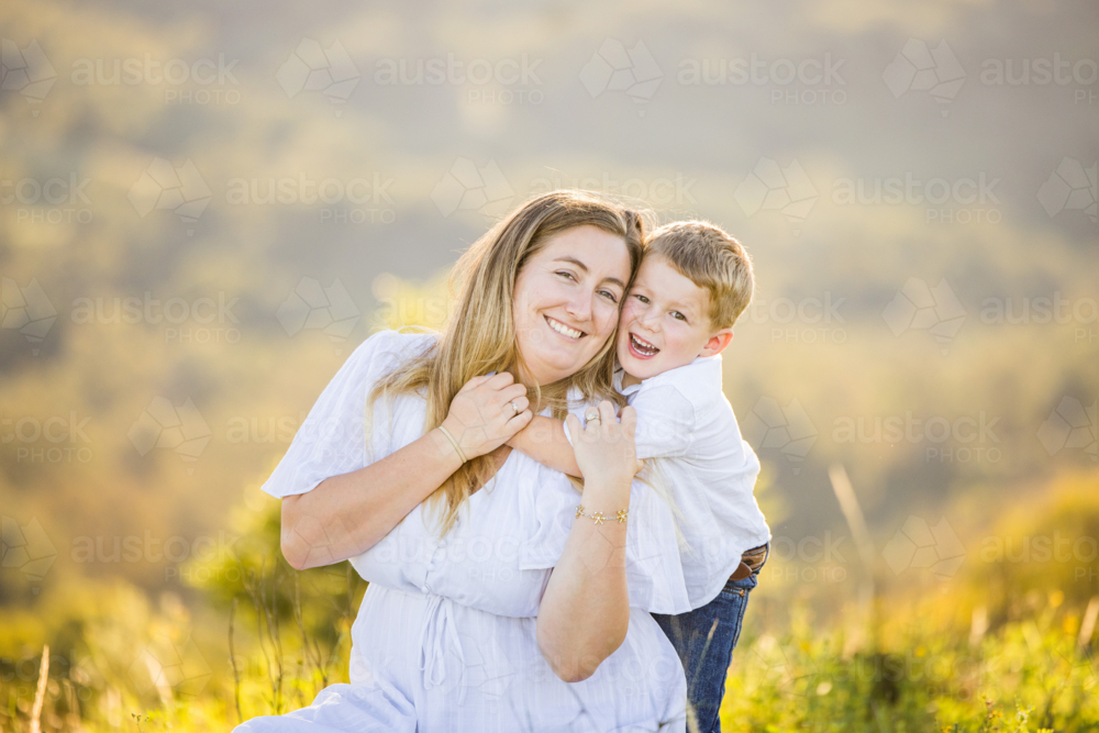 Image of Mother and son embracing in intimate moment on hilltop ...