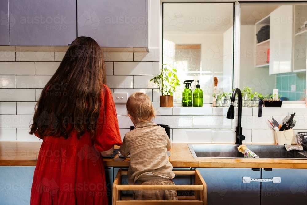 Image of mother and young son cooking together in kitchen doing dinner ...