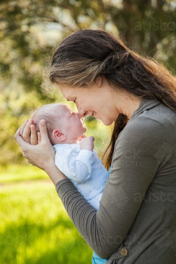 Image of Mother interacting with newborn baby boy outside - Austockphoto