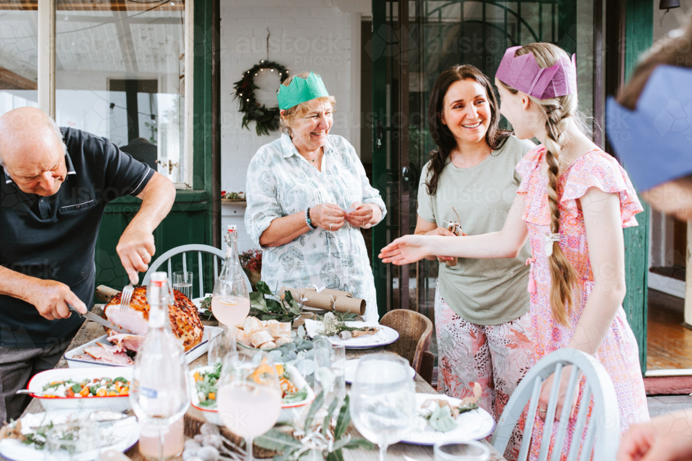 Image of Multigeneration family busy preparing the table for dinner ...