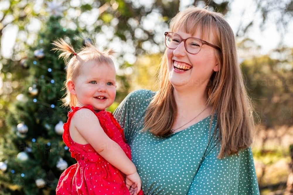 Image of Mum and little girl laughing together outside at Christmas ...