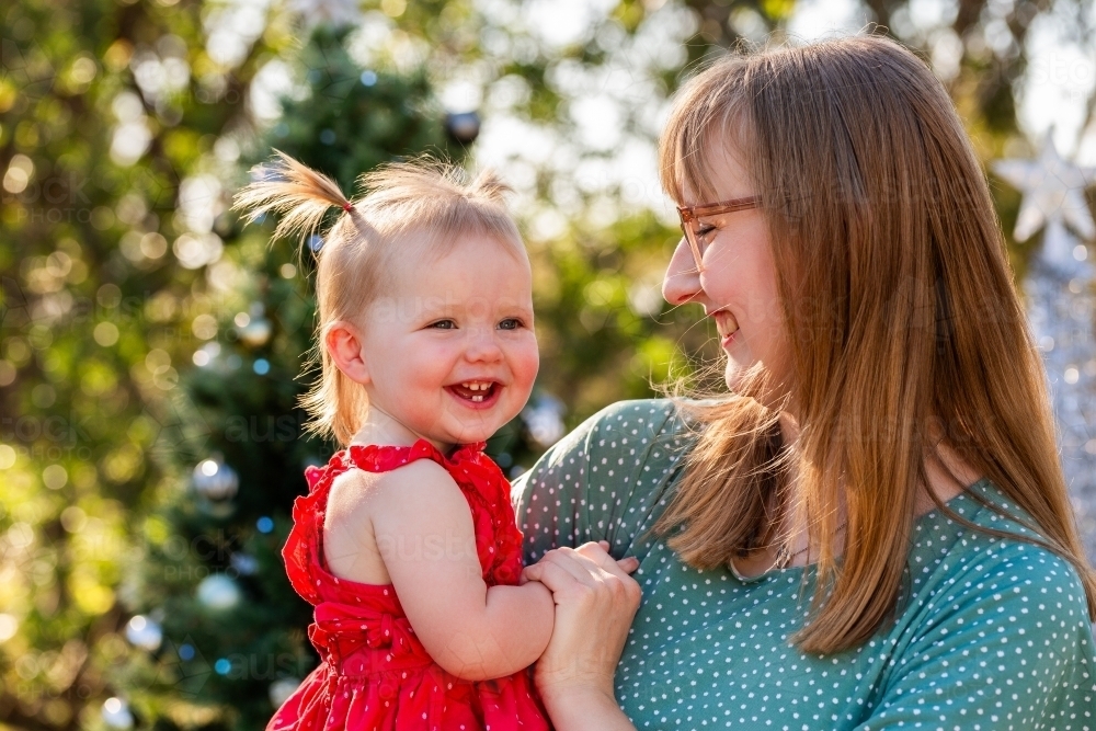 Image of Mum and little girl laughing together outside at Christmas ...