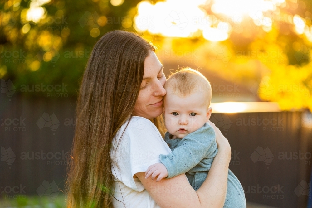 Image of mum holding four month old baby girl in arms outside in golden ...