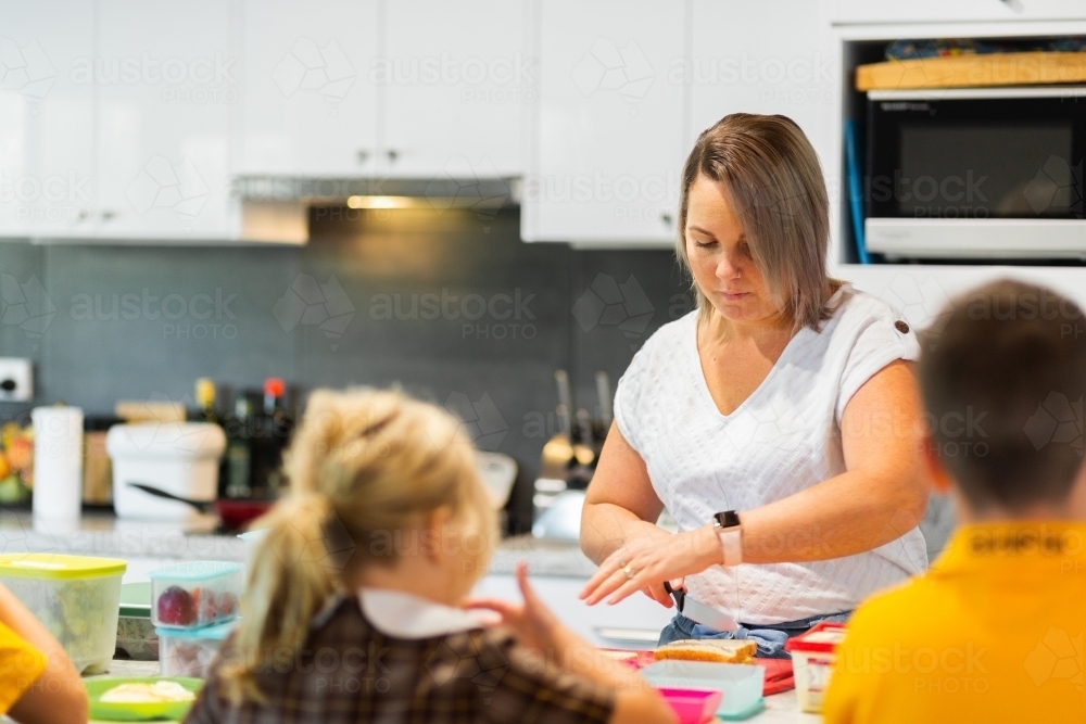 Image of Mum in kitchen making school lunches during breakfast in the ...