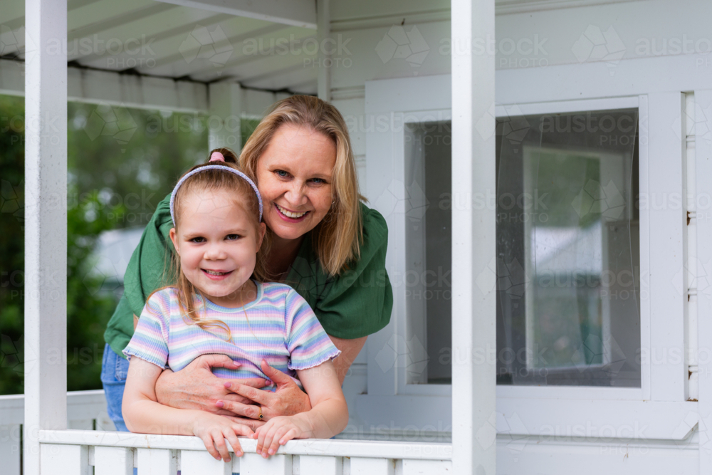 Image of Mum together with daughter hugging by cubby house on farm ...