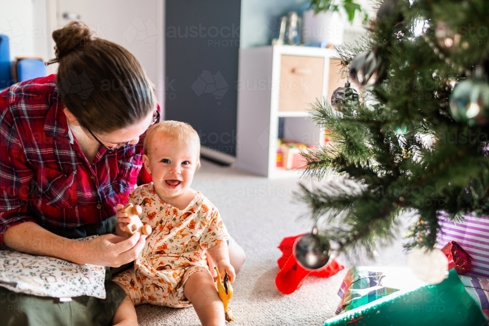 Image of mum with baby beside Christmas tree for baby's first Christmas ...