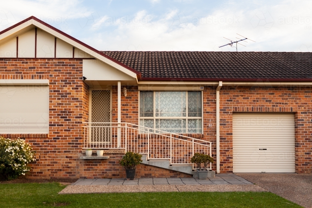 Image of Neat front yard of home and garage door with steps up to house ...