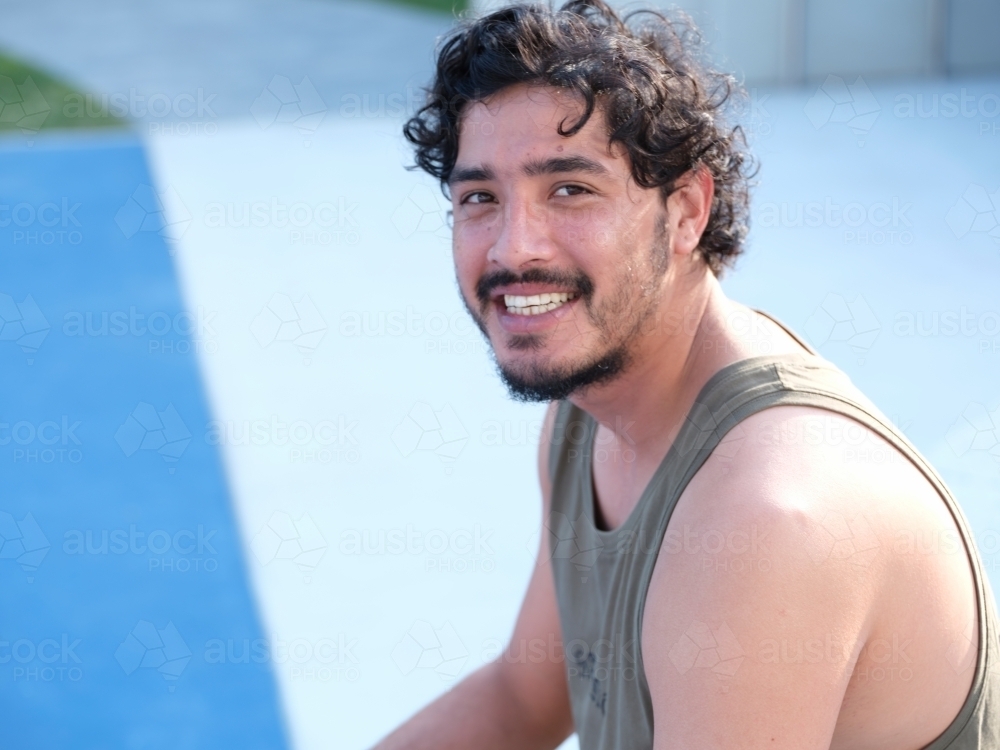 Image of Nepalese man in a green singlet smiling - Austockphoto