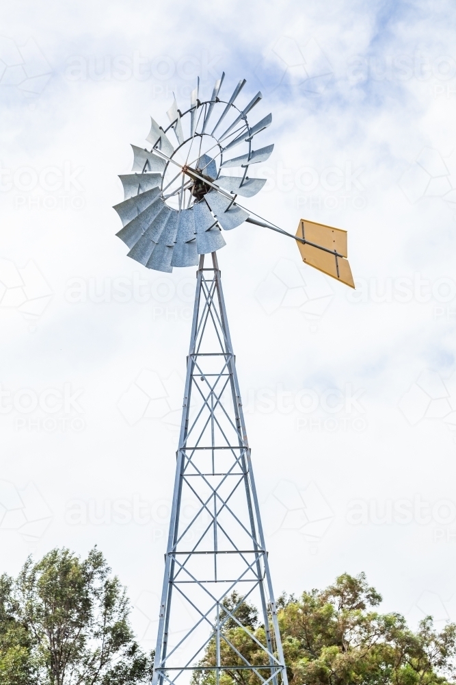 Image of New yellow tail windmill against bright sky with clouds ...