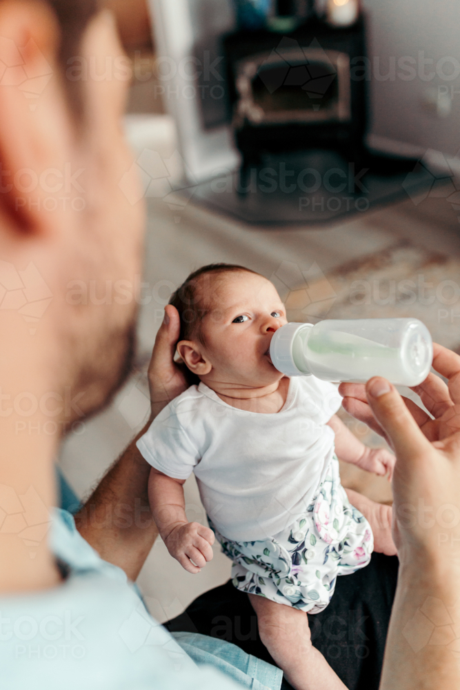 Image of Newborn baby being bottle fed by her father - Austockphoto