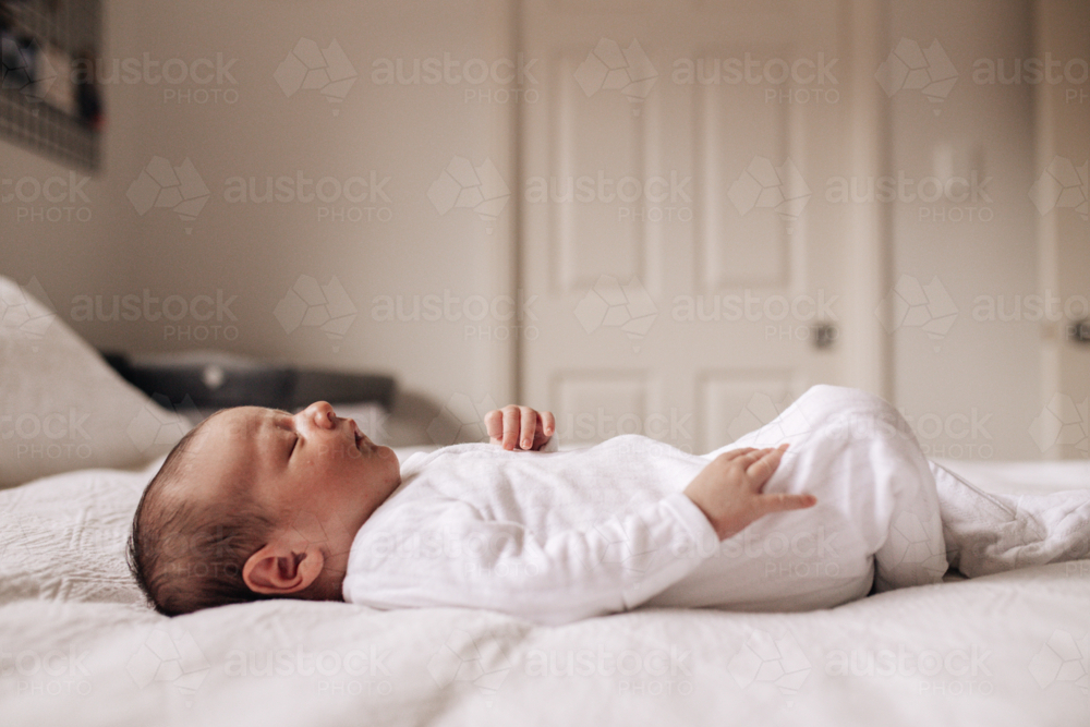 Image of Newborn baby boy lying on his back on the bed - Austockphoto