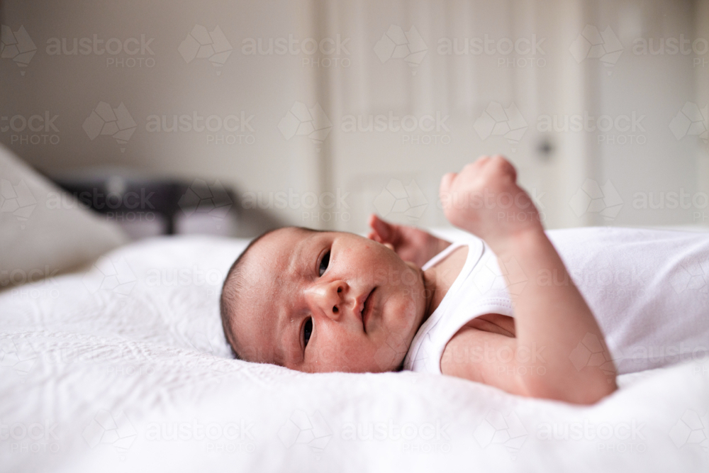 Image of Newborn baby boy lying on his back on the bed - Austockphoto