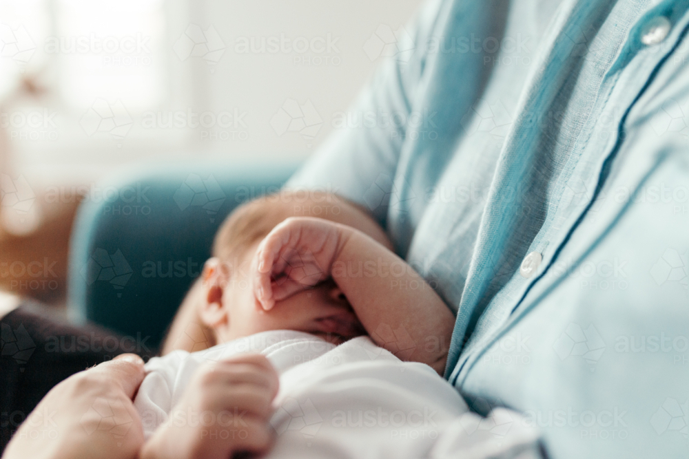Image of Newborn baby girl covering her face while sleeping on father's ...