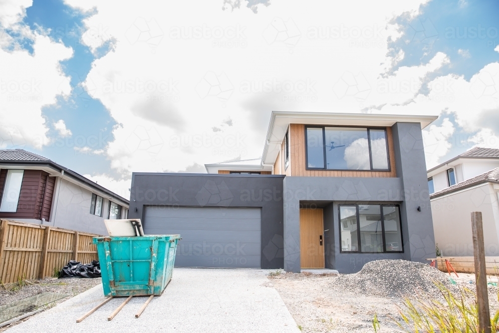 Image of newly constructed house with a skip bin on the driveway ...