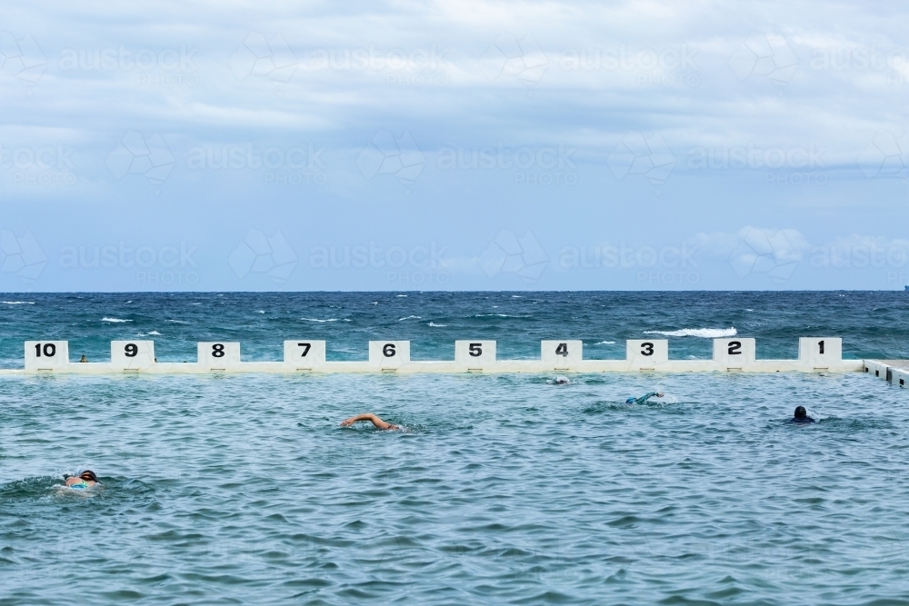 Image of Numbered lane marker at ocean pool with people swimming laps ...