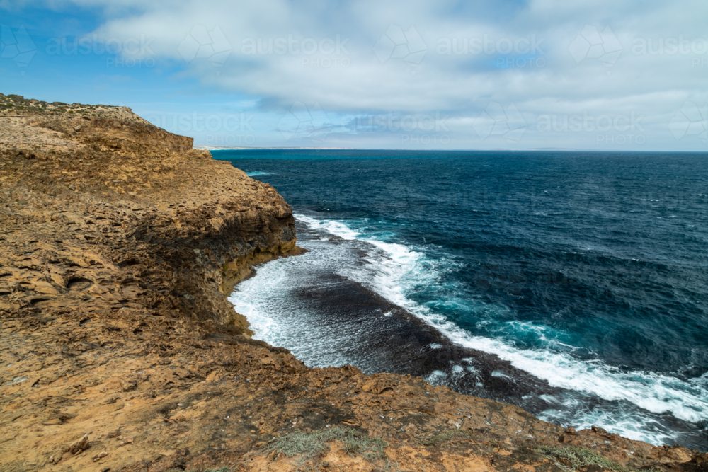 Image of Ocean waves lapping onto coastal rock shelf. - Austockphoto