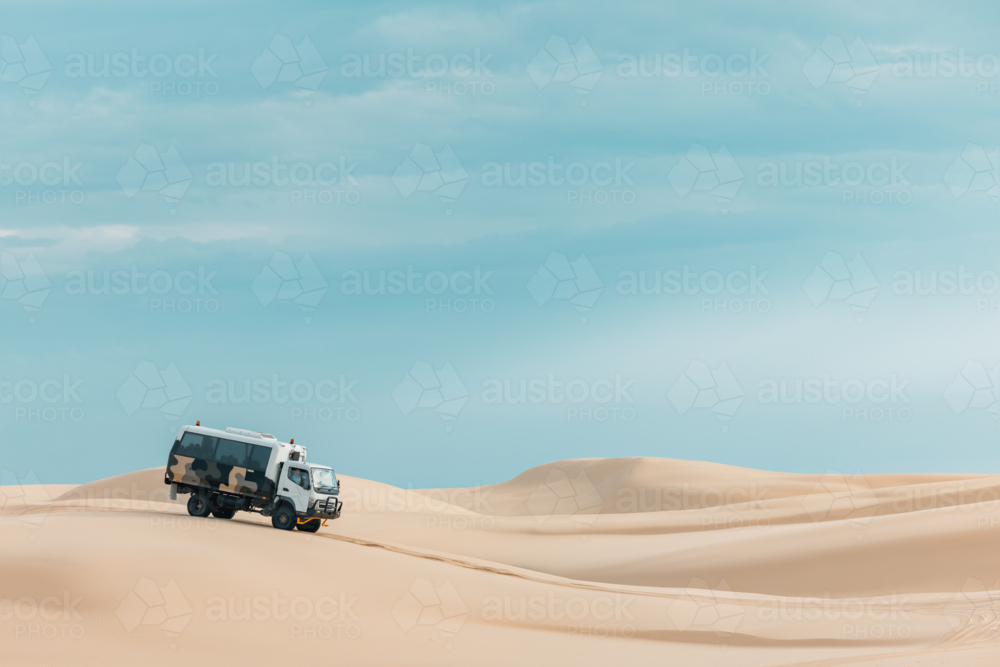 Image of Off-road tour company bus driving down sand dunes at Birubi ...